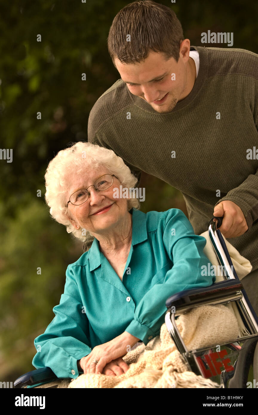 pushing senior senior citizen in wheel chair Stock Photo - Alamy