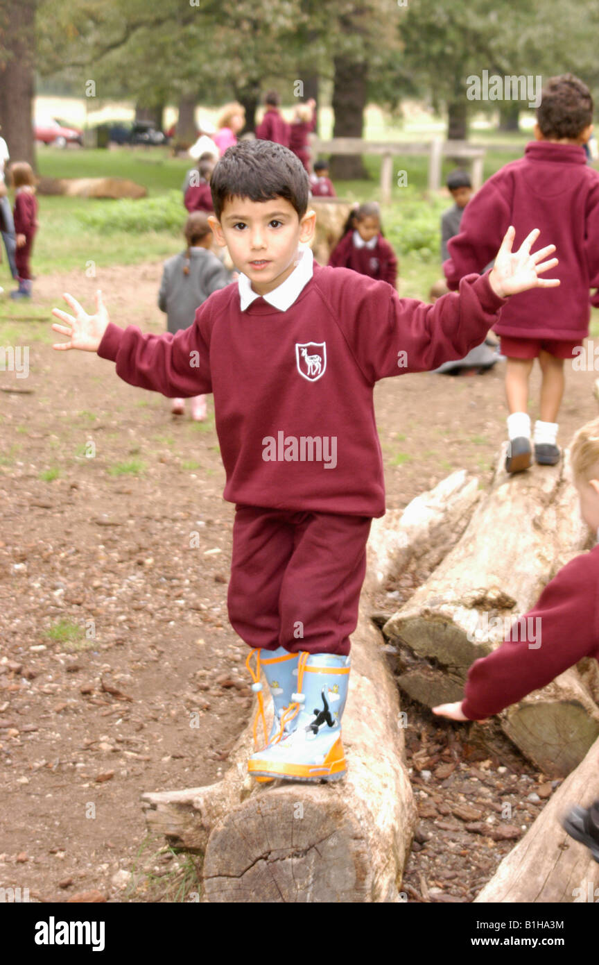 boy balancing on a log in a school playground Stock Photo - Alamy
