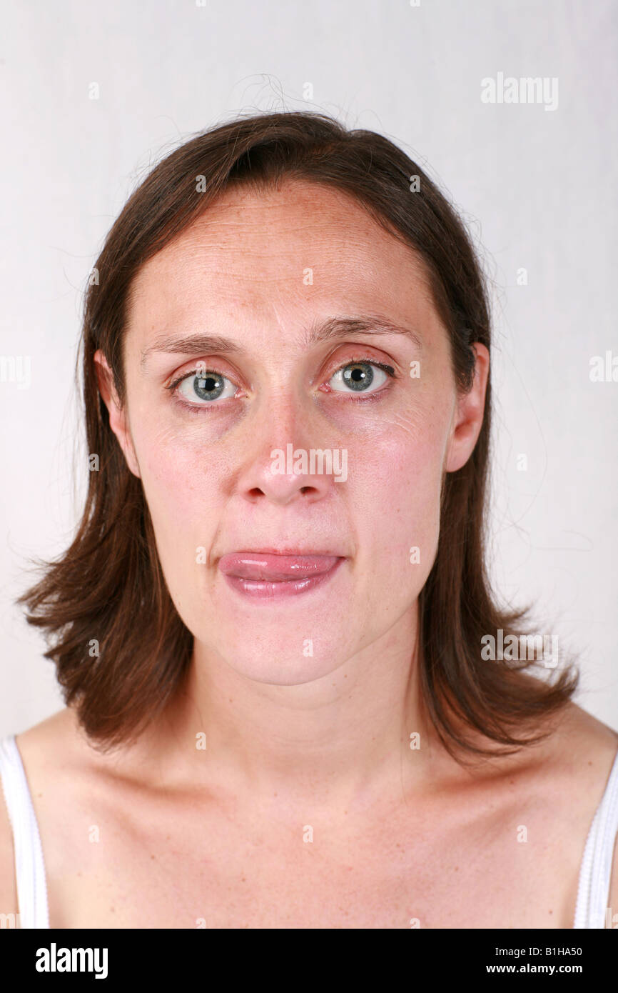 Young woman licking lips biting tongue showing facial concentration ...