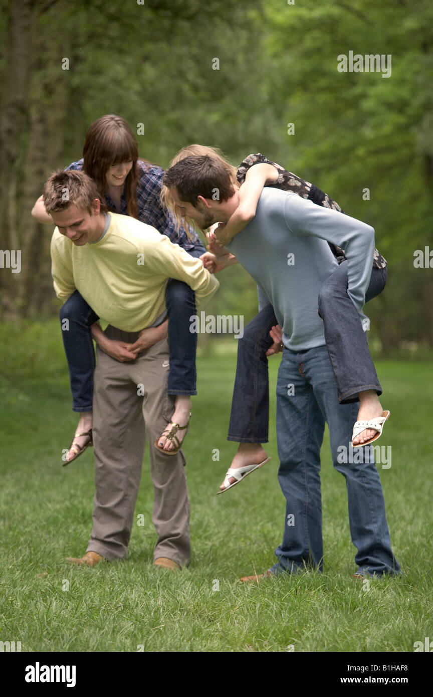 Two couples playing piggyback Stock Photo - Alamy