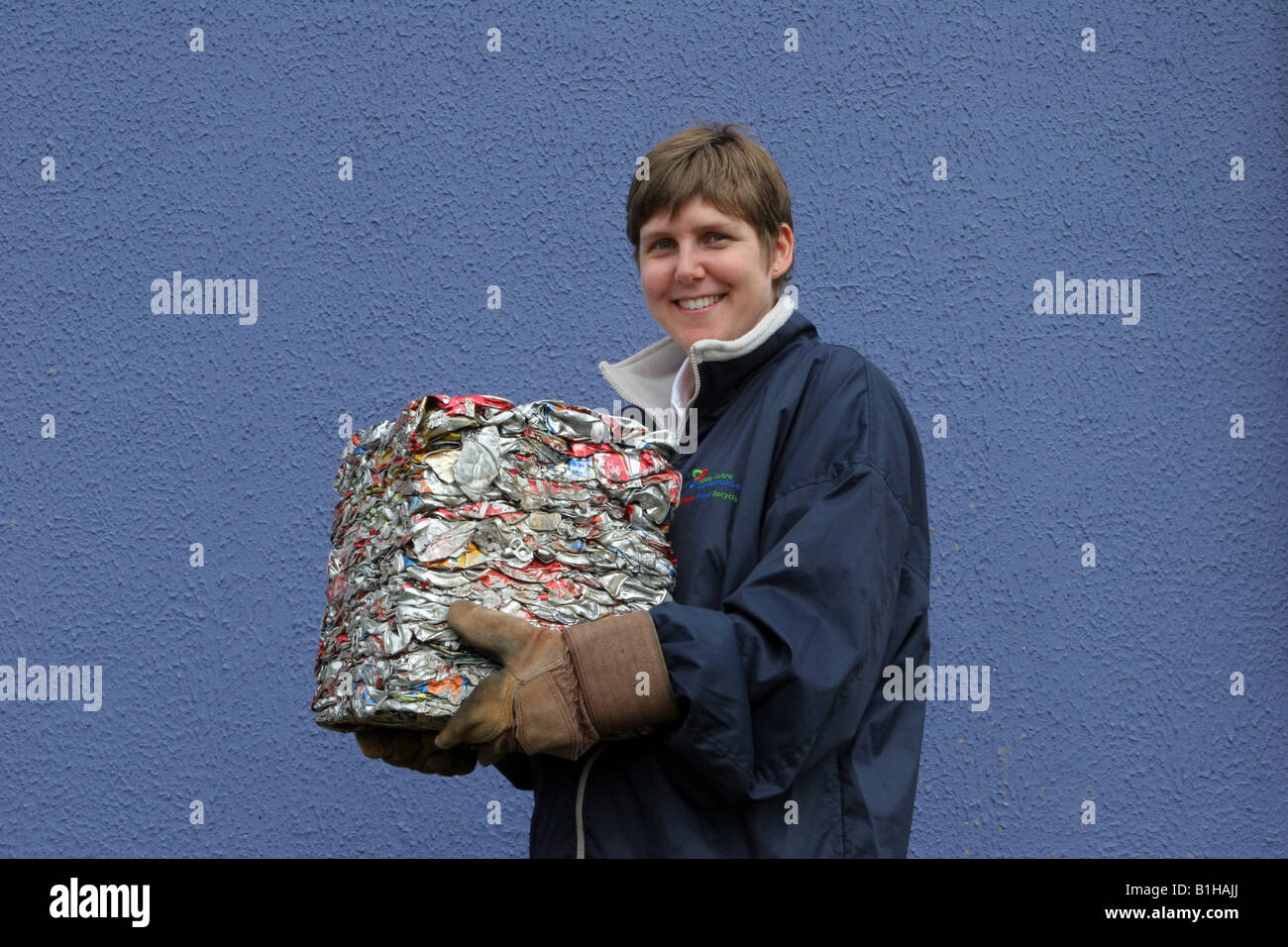 Council employee holding recycled metal trash, refuse, crushed, garbage ...
