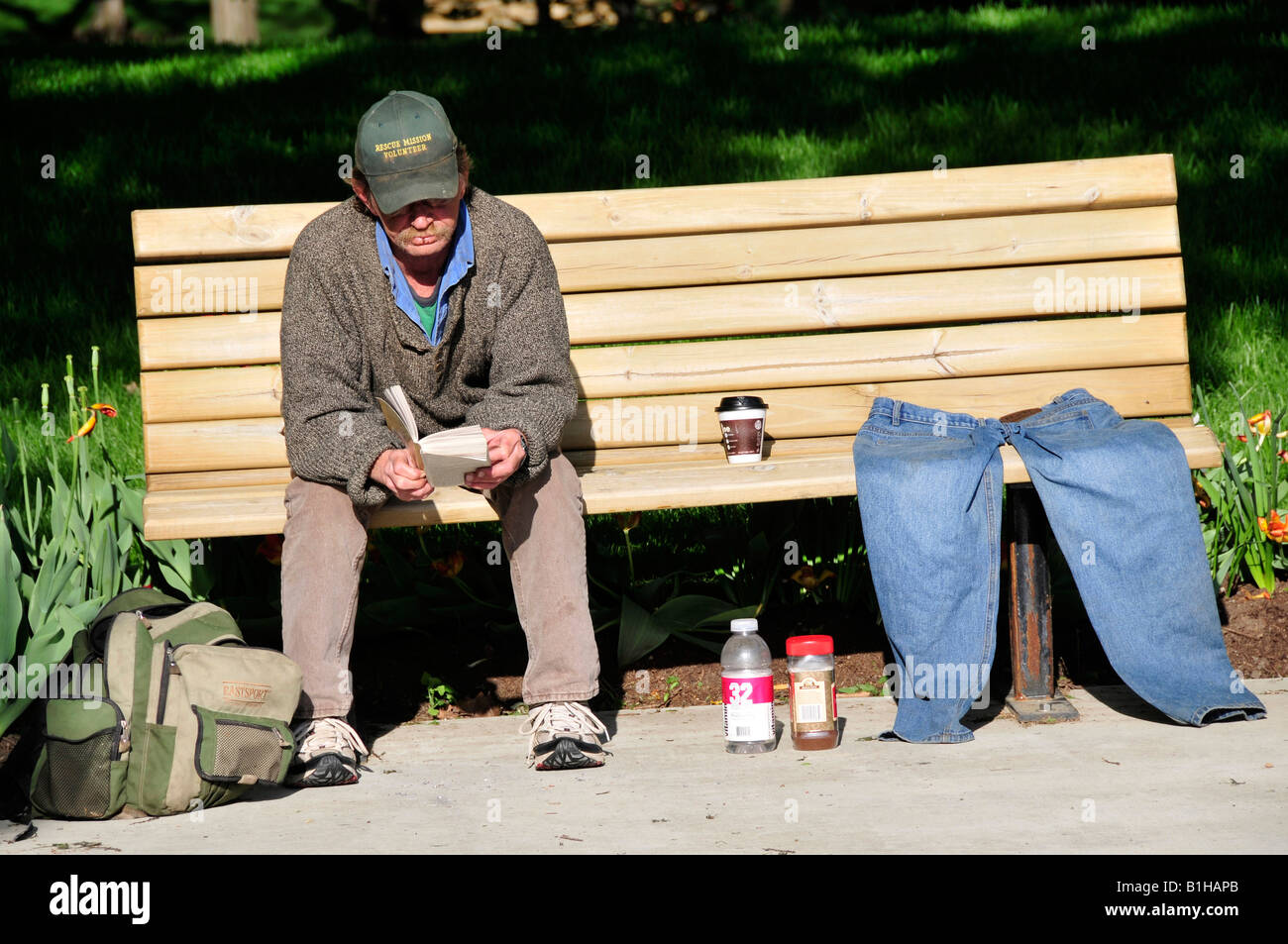 Homeless man reading book on park bench in Fort Wayne Indiana Stock ...