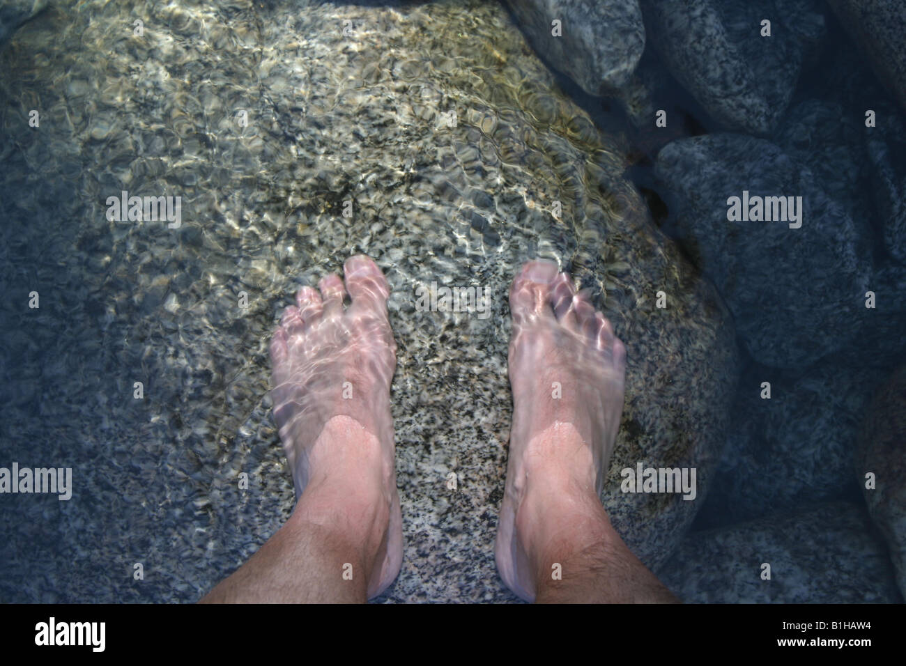 Male feet in water Stock Photo - Alamy