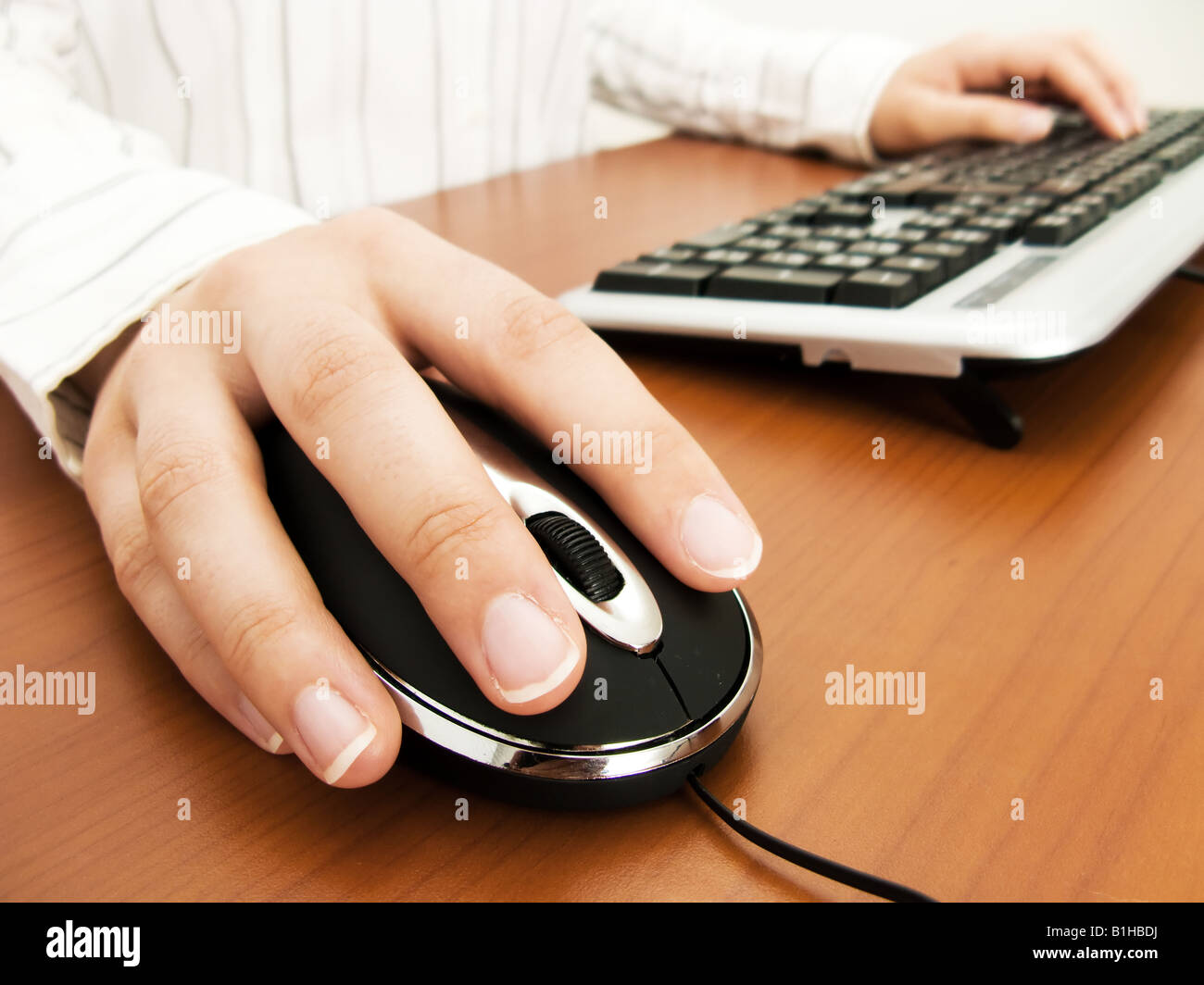 Businesswoman typing in the computer keyboard and using a mouse Stock ...