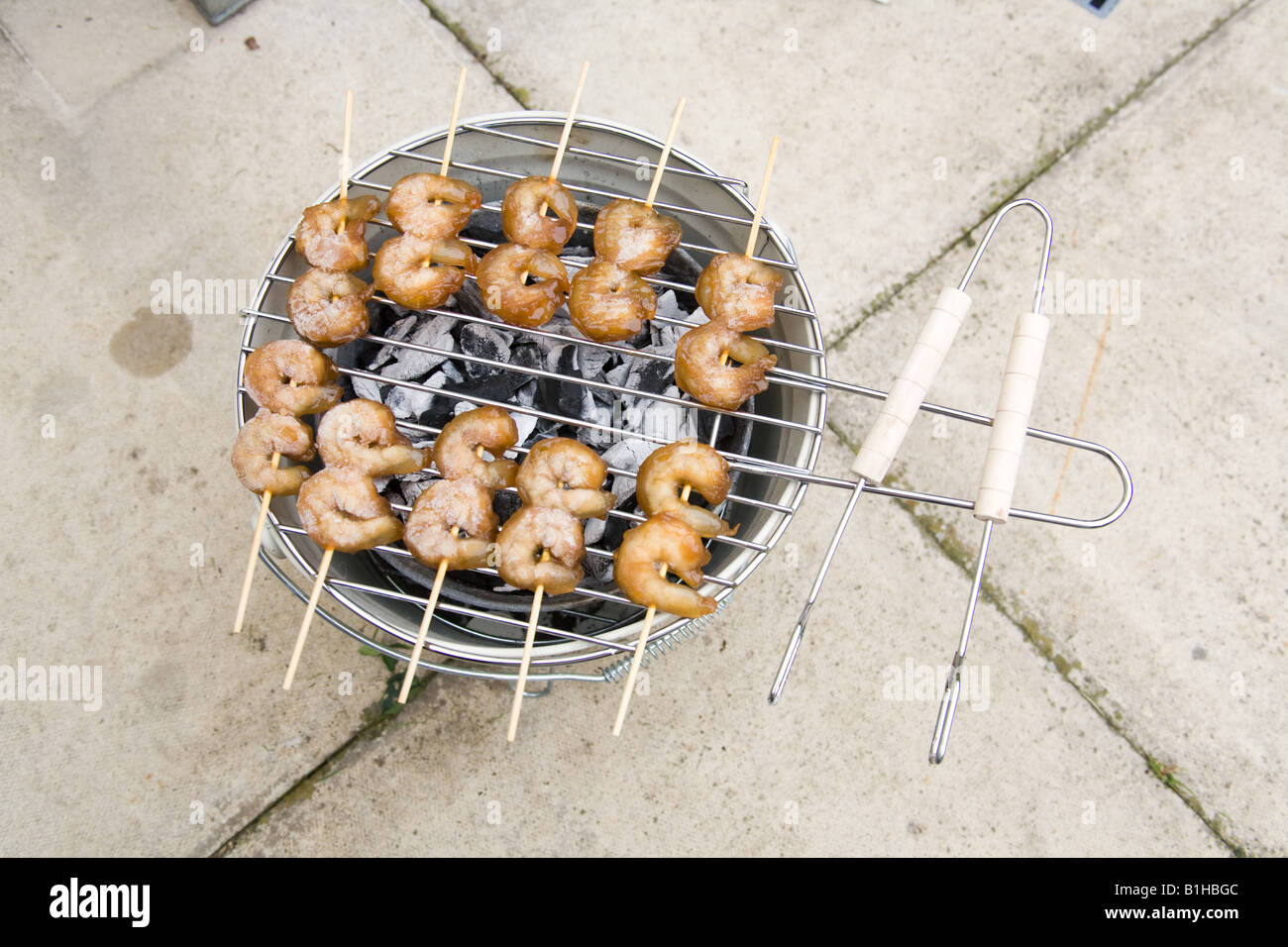 Bucket barbecue with tiger prawn kebabs cooking, London,England Stock ...