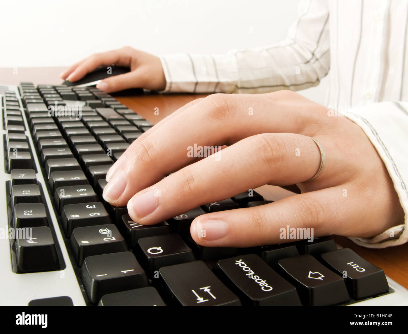 Businesswoman typing in the computer keyboard and using a mouse Stock ...