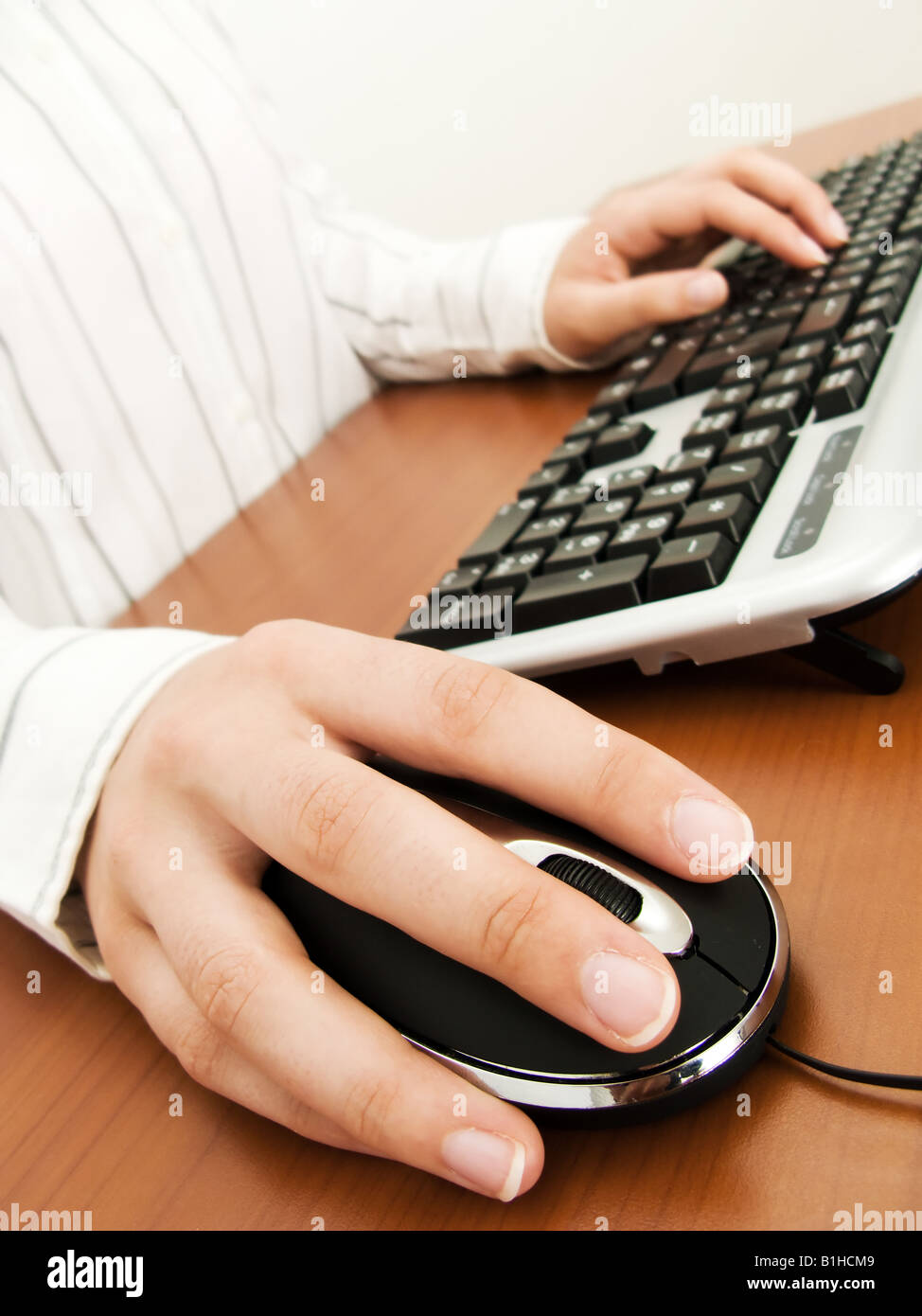Businesswoman typing in the computer keyboard and using a mouse Stock ...