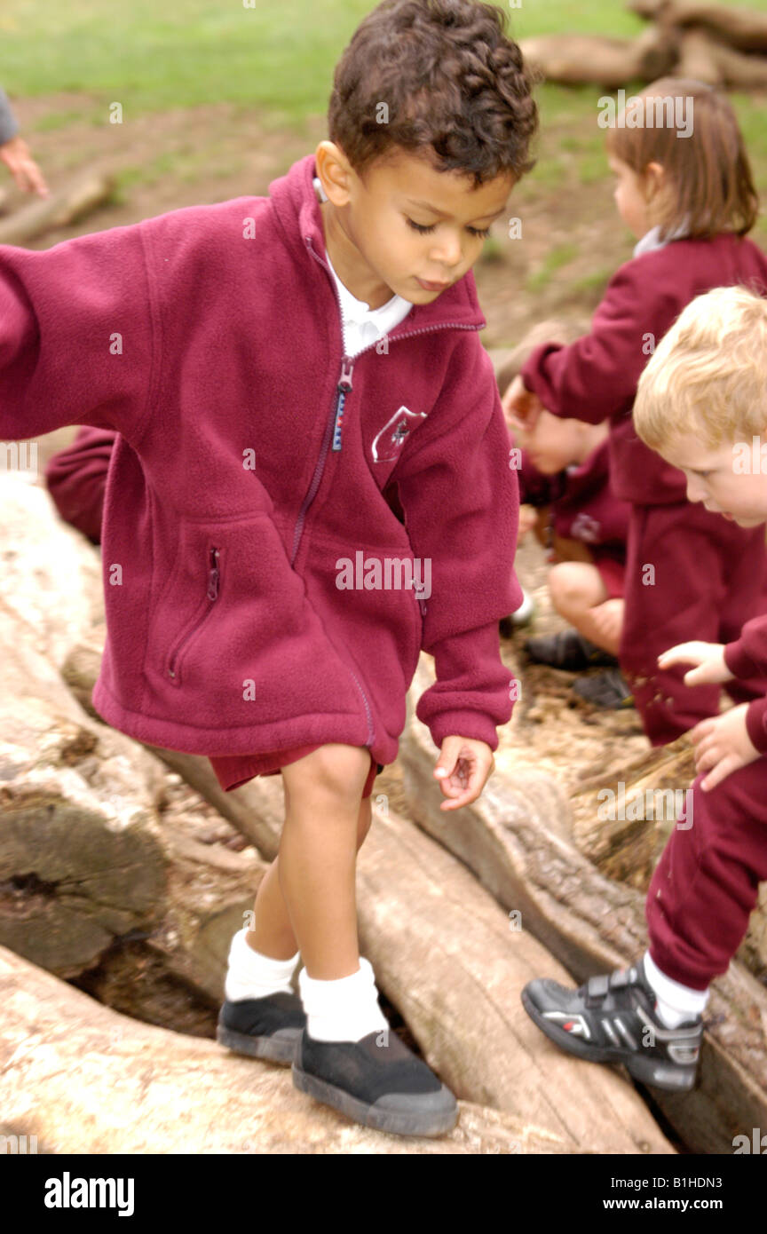 primary school boy balancing on a log outdoors Stock Photo - Alamy