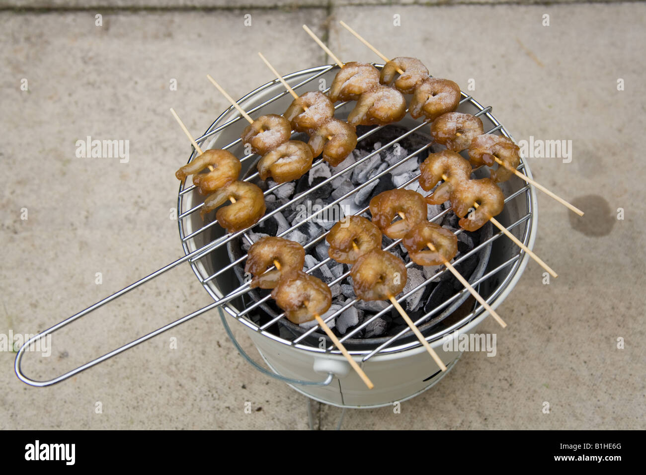 Bucket barbecue with tiger prawn kebabs cooking, London,England Stock ...