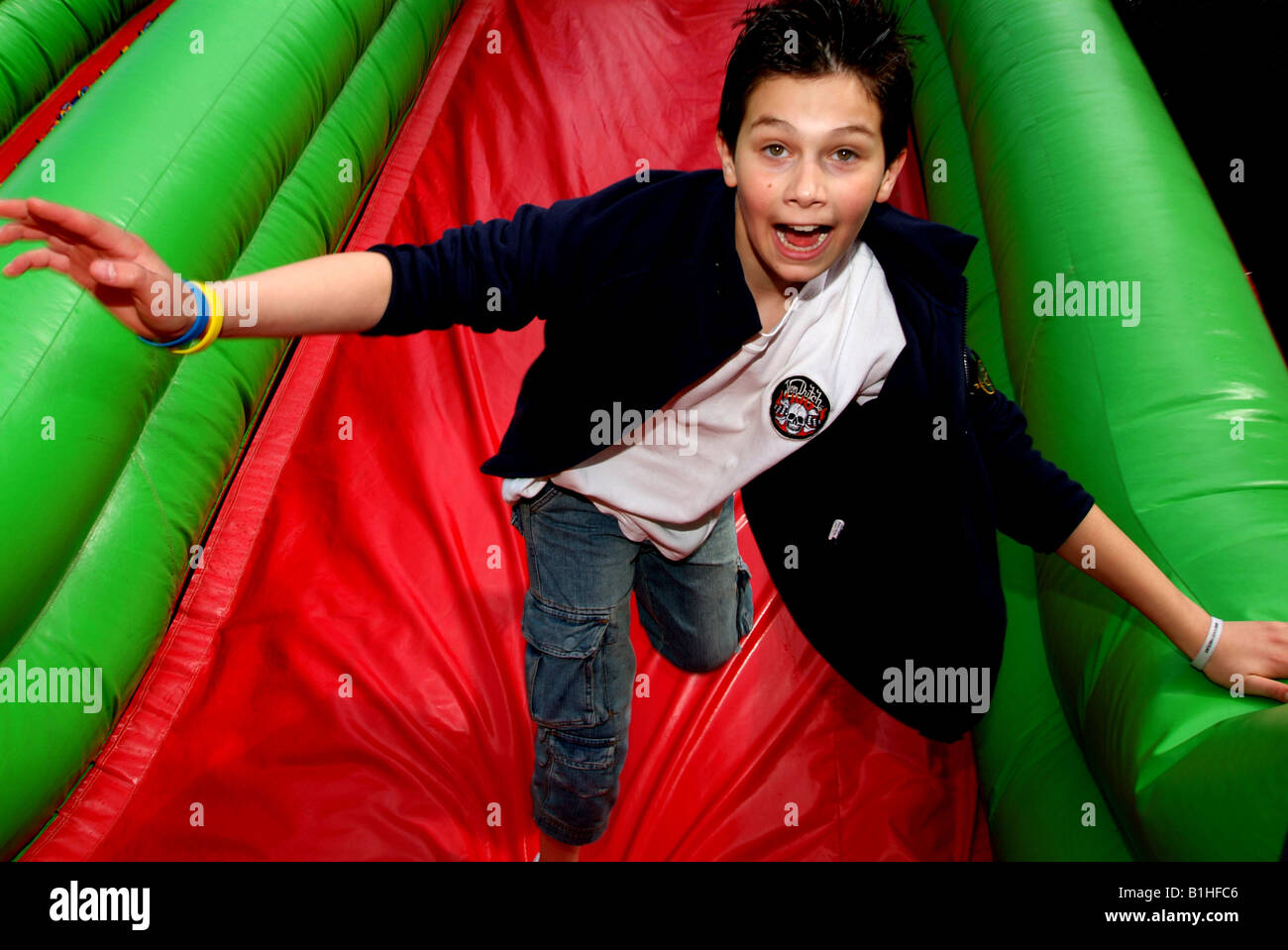 young boy falling forward at party on an inflatable slide bouncy castle ...