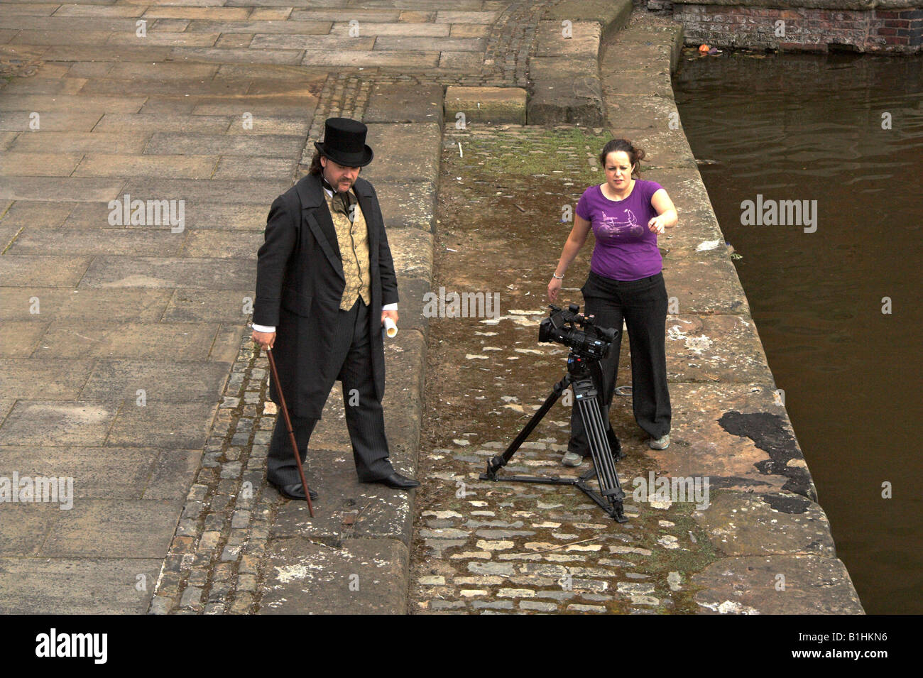 Man in Victorian costume, people filming in Castlefield, Manchester, UK ...