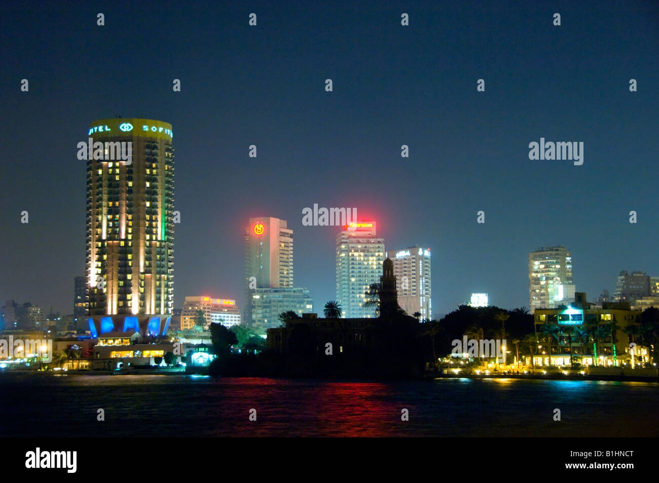 The Cairo, Egypt skyline with high rise buildings illuminated at dusk ...