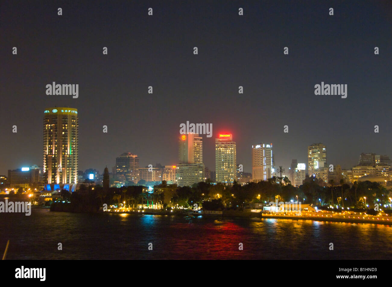 The Cairo, Egypt skyline with high rise buildings illuminated at dusk ...