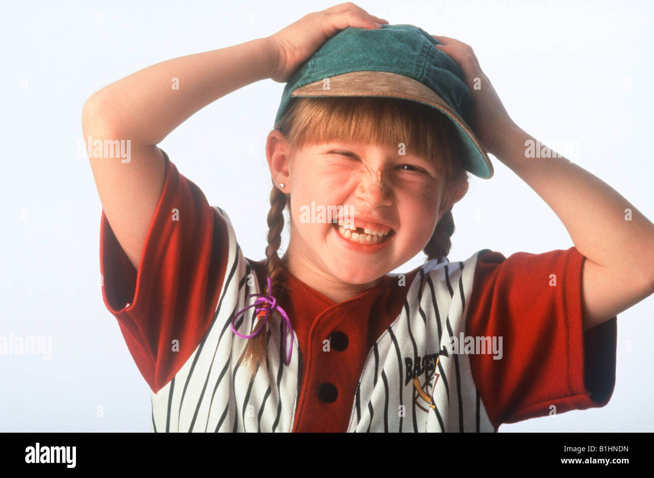 A girl with her front tooth missing, smiling before a game of baseball ...