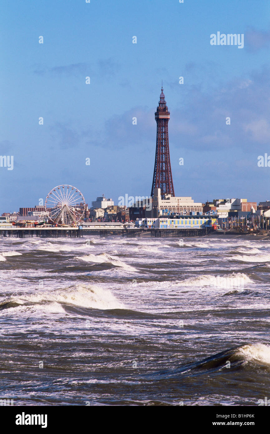 Waves in the sea with a tower and a ferris wheel in the background ...
