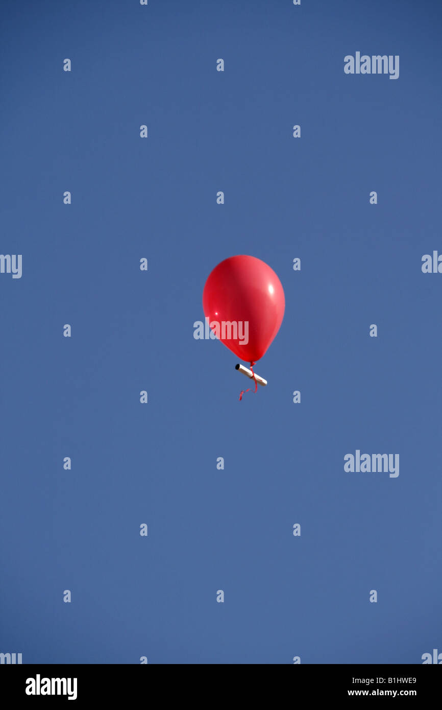 one red balloon floating up in blue sky Stock Photo - Alamy