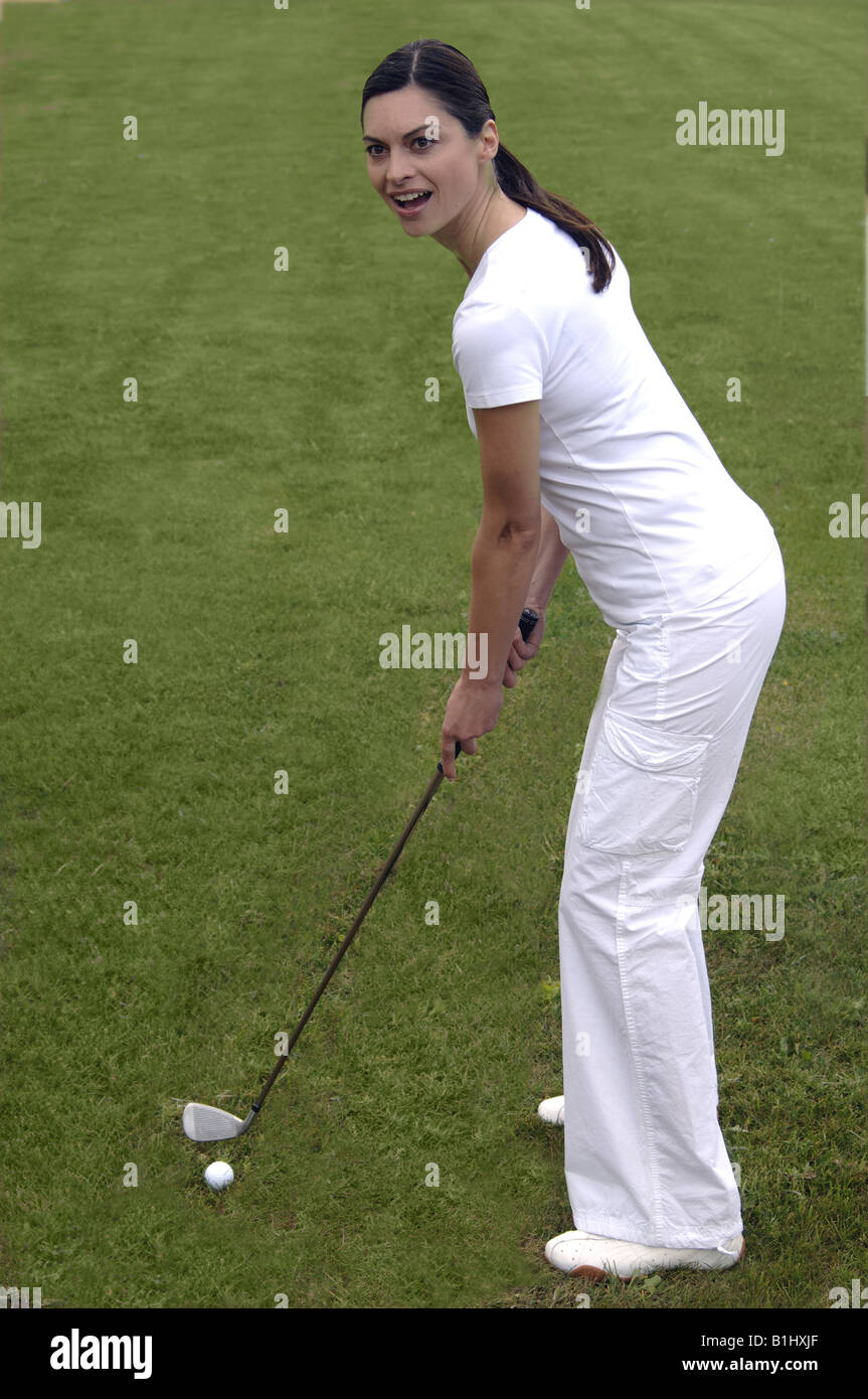 Woman tees off Stock Photo - Alamy