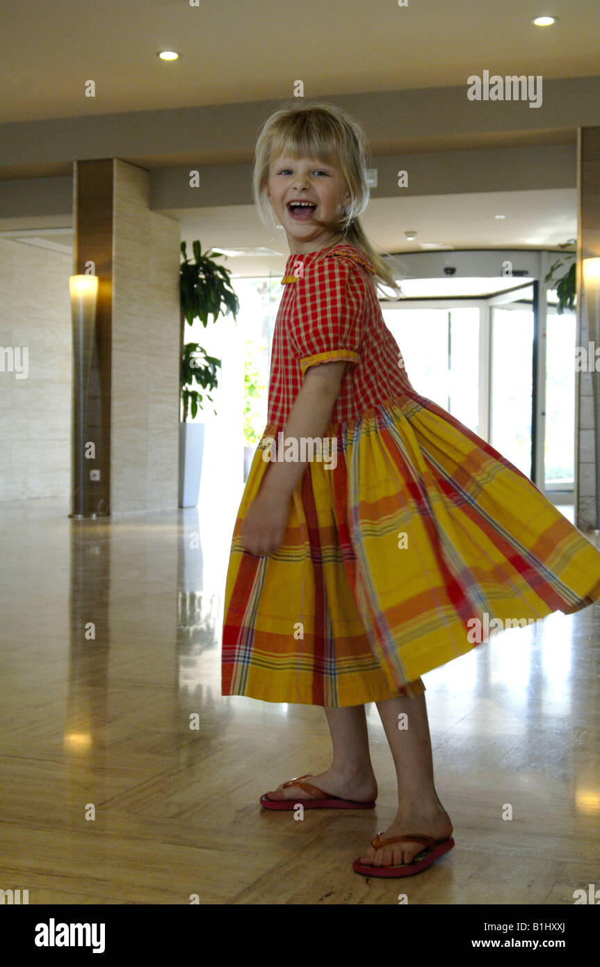 Little girl in a yellow and red checked dress Stock Photo - Alamy