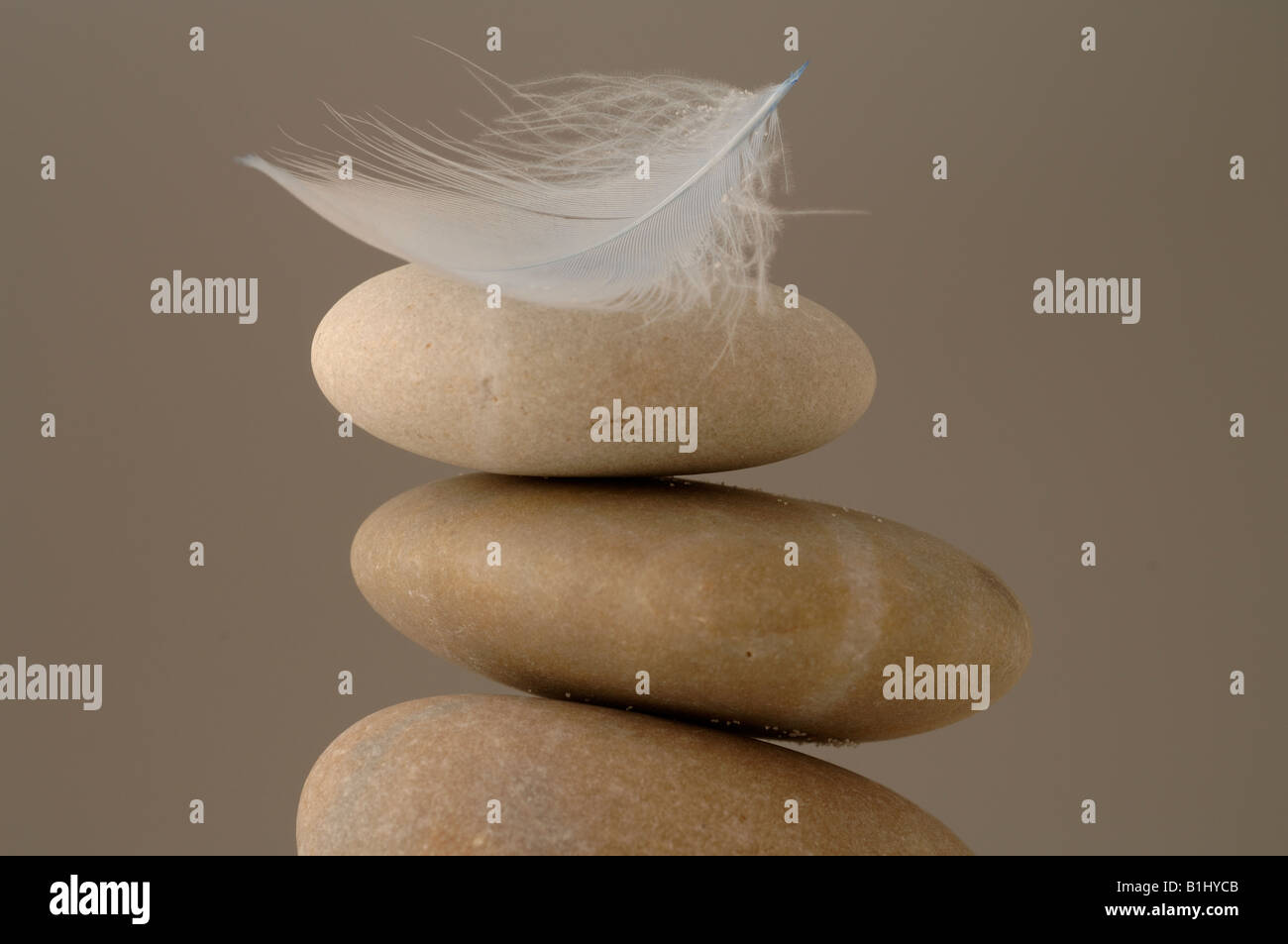 Stacked stones with a feather Stock Photo - Alamy