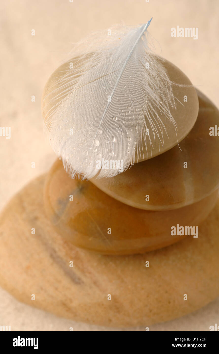 Stacked stones with a feather Stock Photo - Alamy