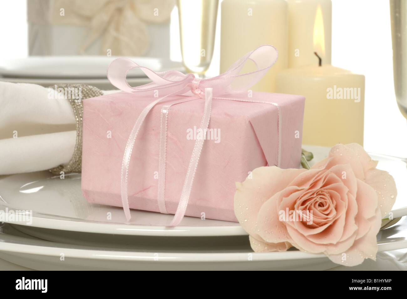 Table decoration with pink rose and present Stock Photo - Alamy