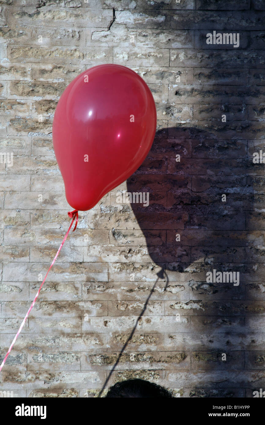 one red balloon floating against wall Stock Photo - Alamy
