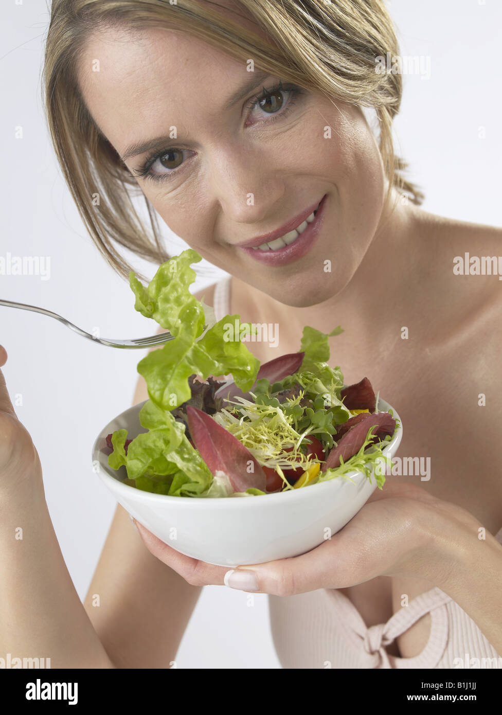 Woman is eating salad Stock Photo - Alamy
