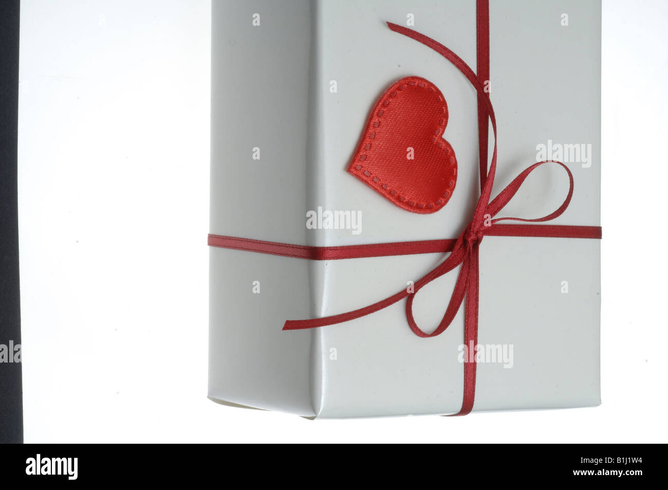 White wrapped gift with a red heart Stock Photo - Alamy