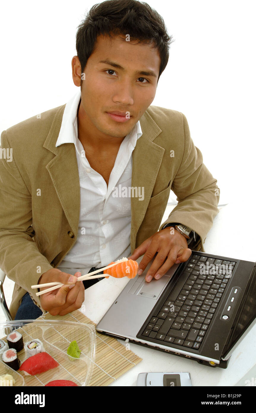 Asian man eating sushi at the desk Stock Photo - Alamy
