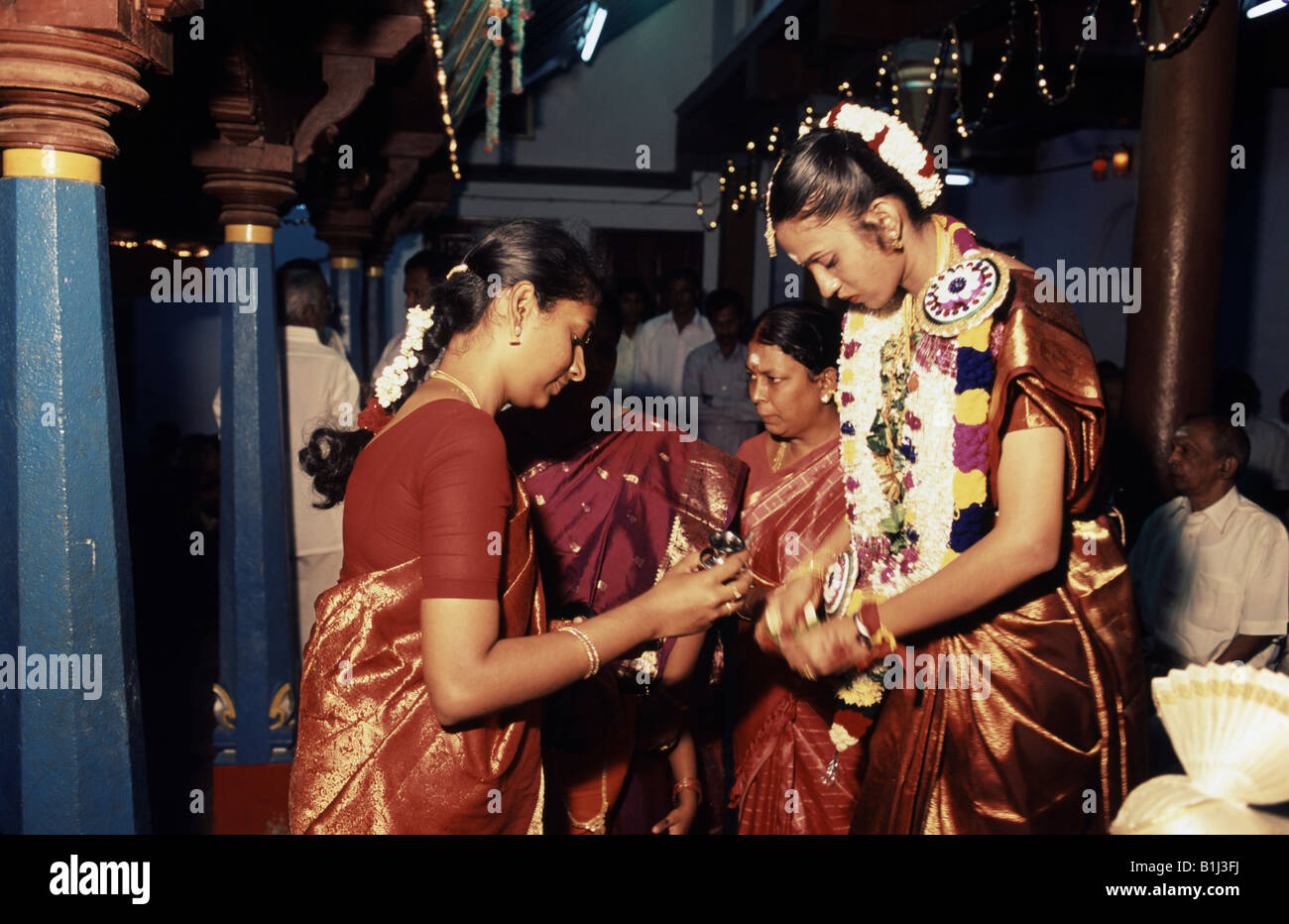 Side profile of a mid adult woman preparing bride in a wedding ceremony ...
