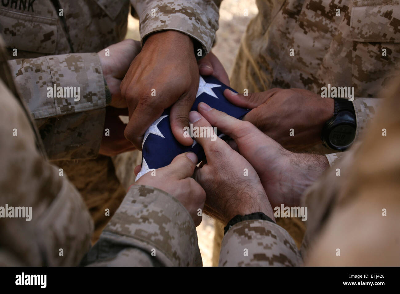 Marines fold an American flag after it was raised in memory of a fallen ...