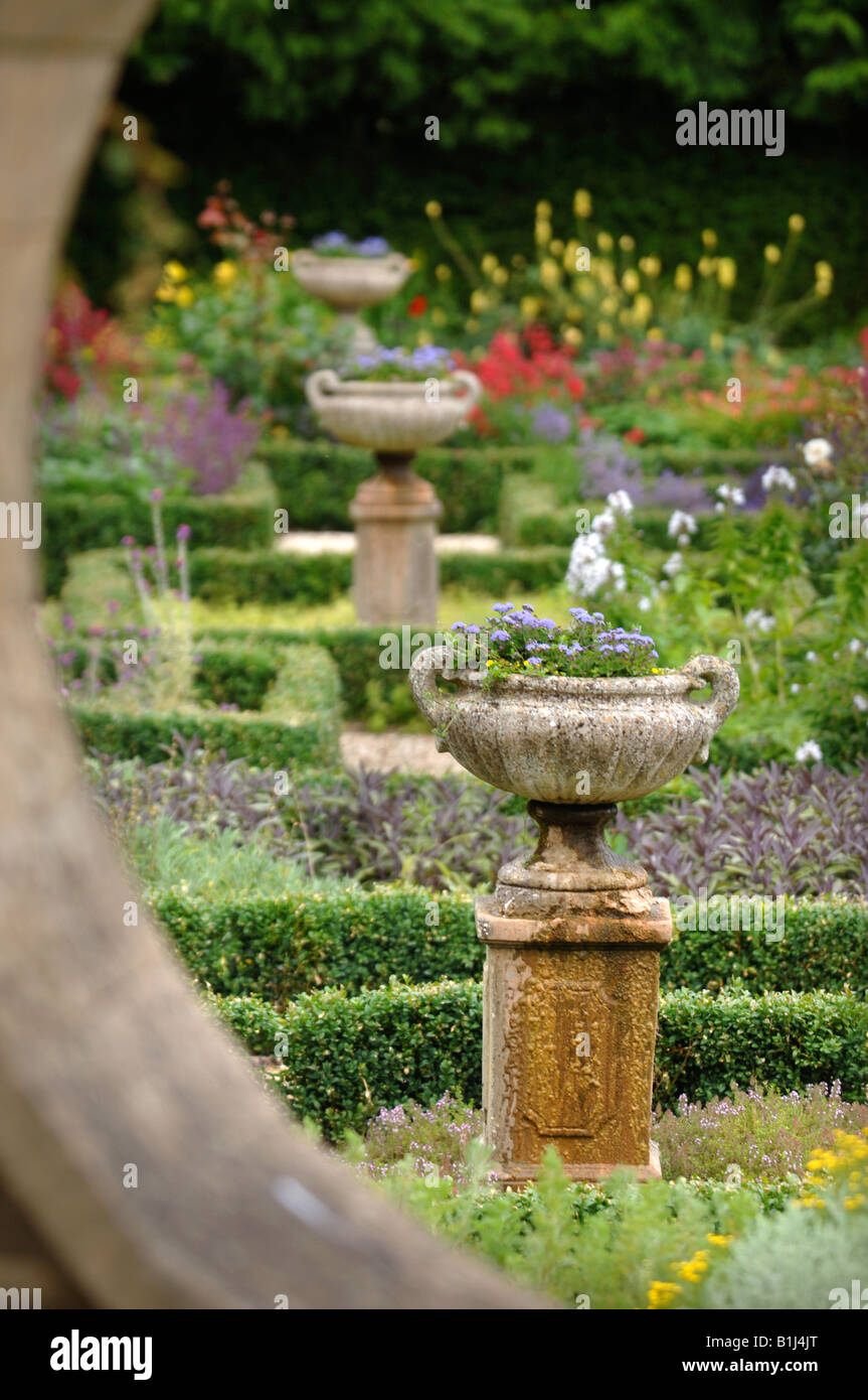THREE STONE URNS IN A GARDEN WITH PATHS FLANKED BY DWARF BOX HEDGES UK ...