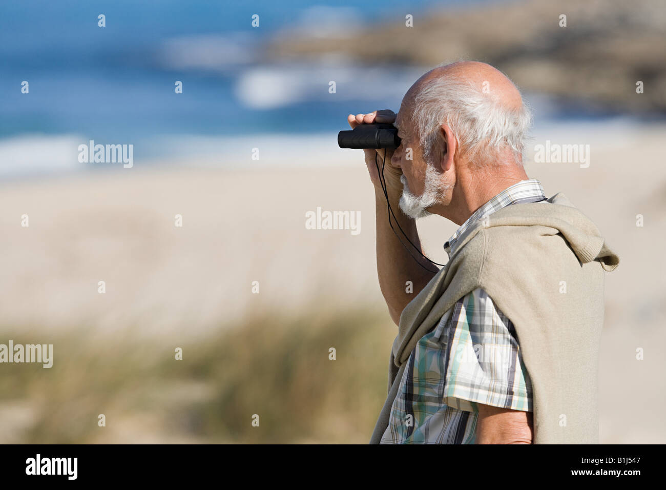 Senior man using binoculars Stock Photo - Alamy