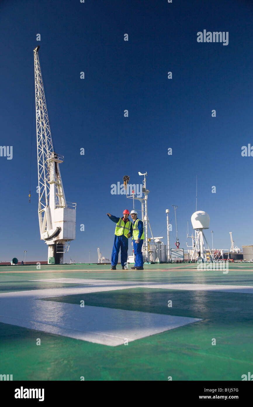 Two harbour workers on a ship deck Stock Photo - Alamy