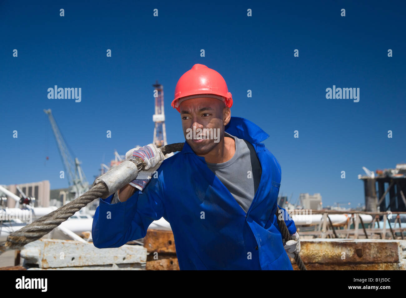 A harbour worker pulling a rope Stock Photo - Alamy