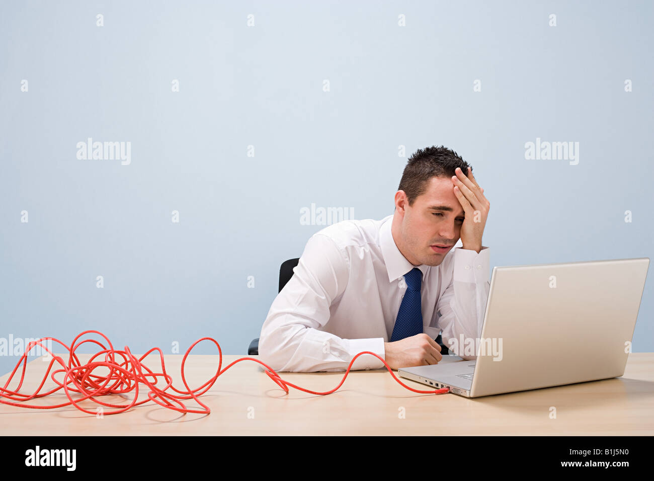 Stressed man looking at laptop Stock Photo - Alamy