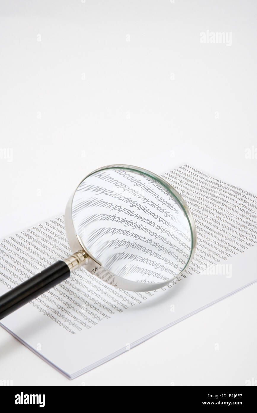 Magnifying glass and a stack of paper Stock Photo - Alamy