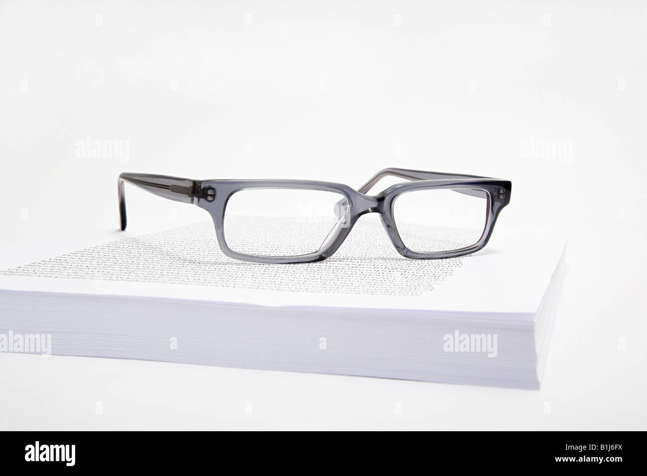 Eyeglasses and a stack of paper Stock Photo - Alamy
