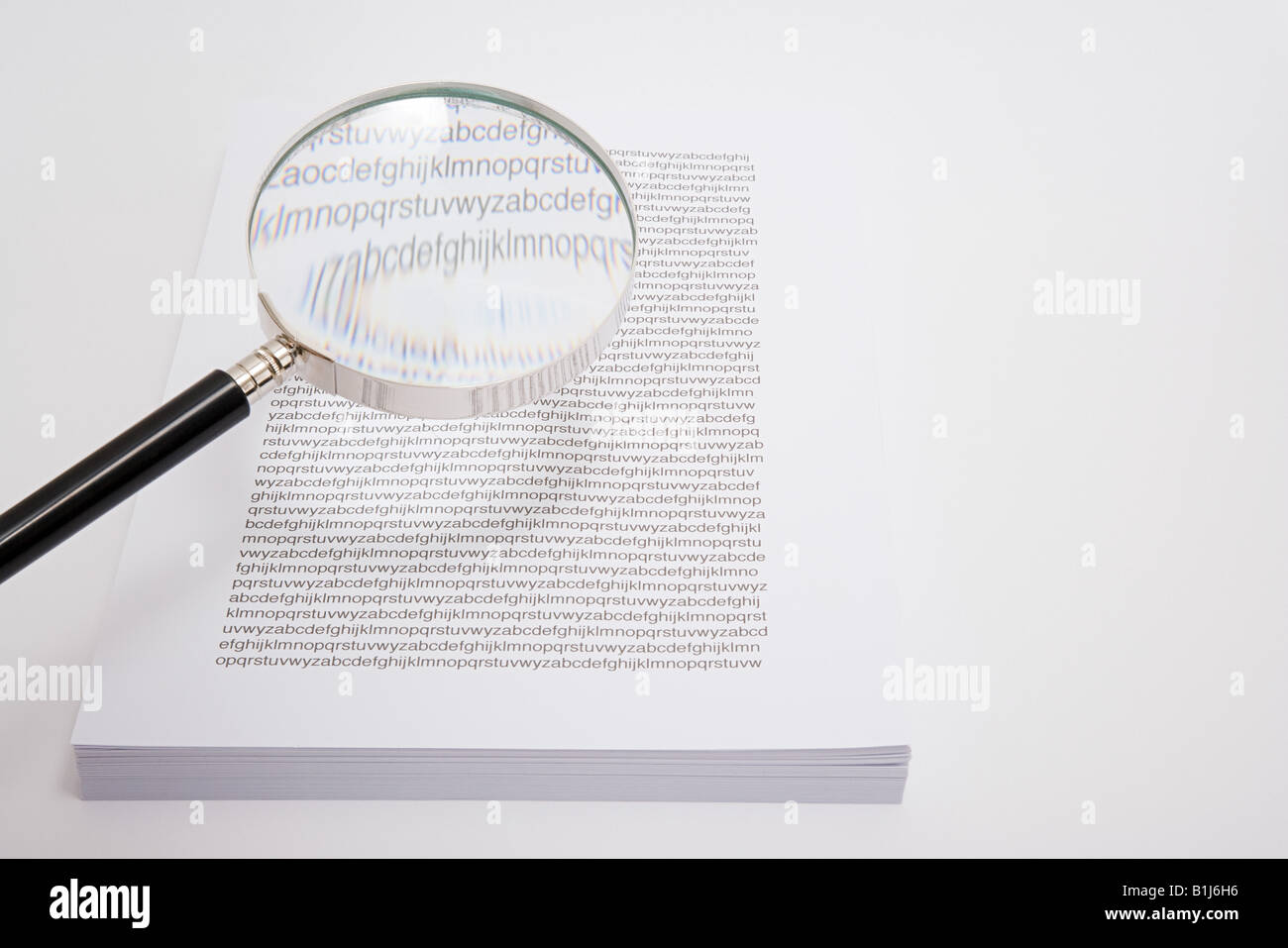 Magnifying glass and a stack of paper Stock Photo - Alamy
