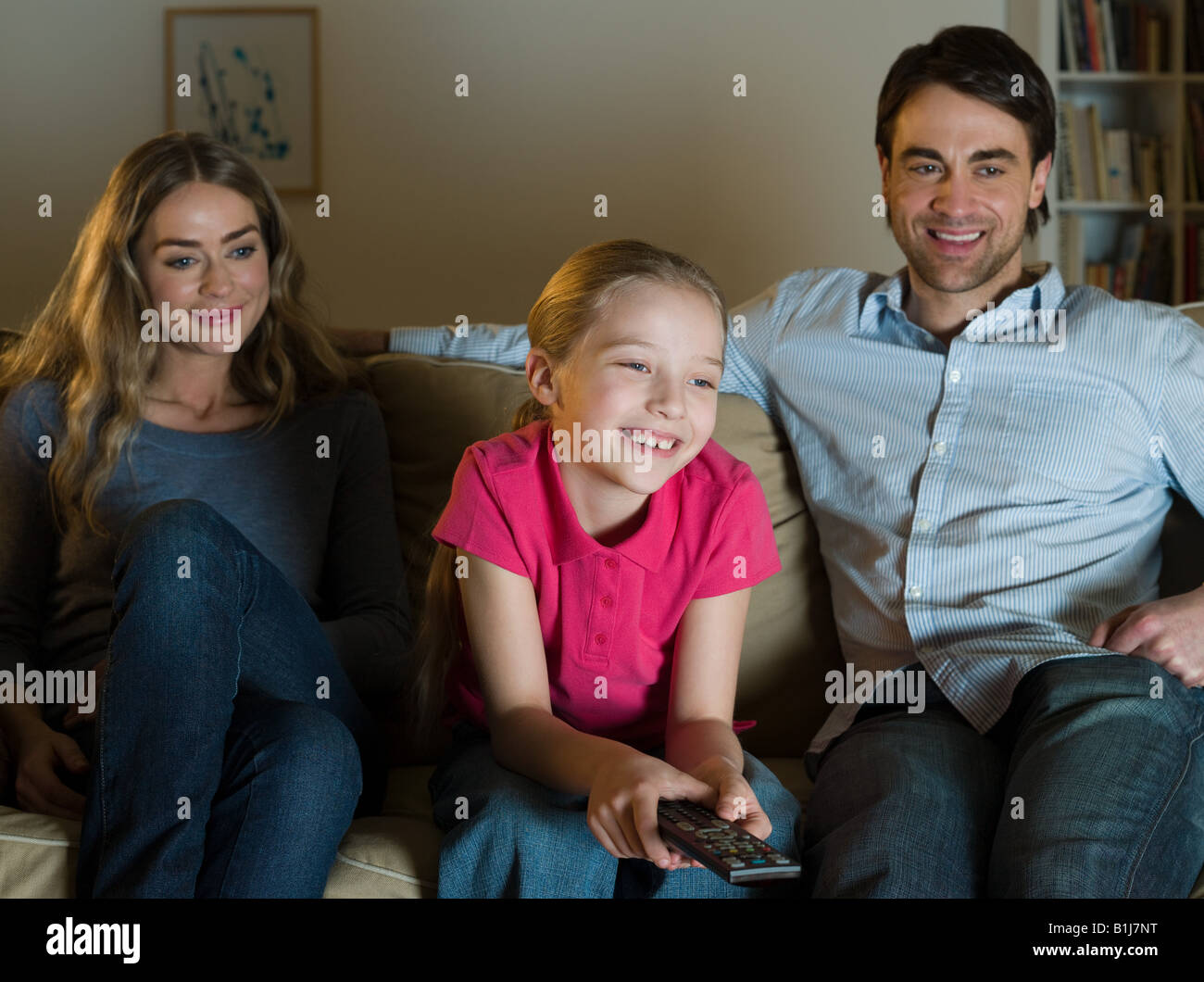 Parents watching tv with their daughter Stock Photo - Alamy