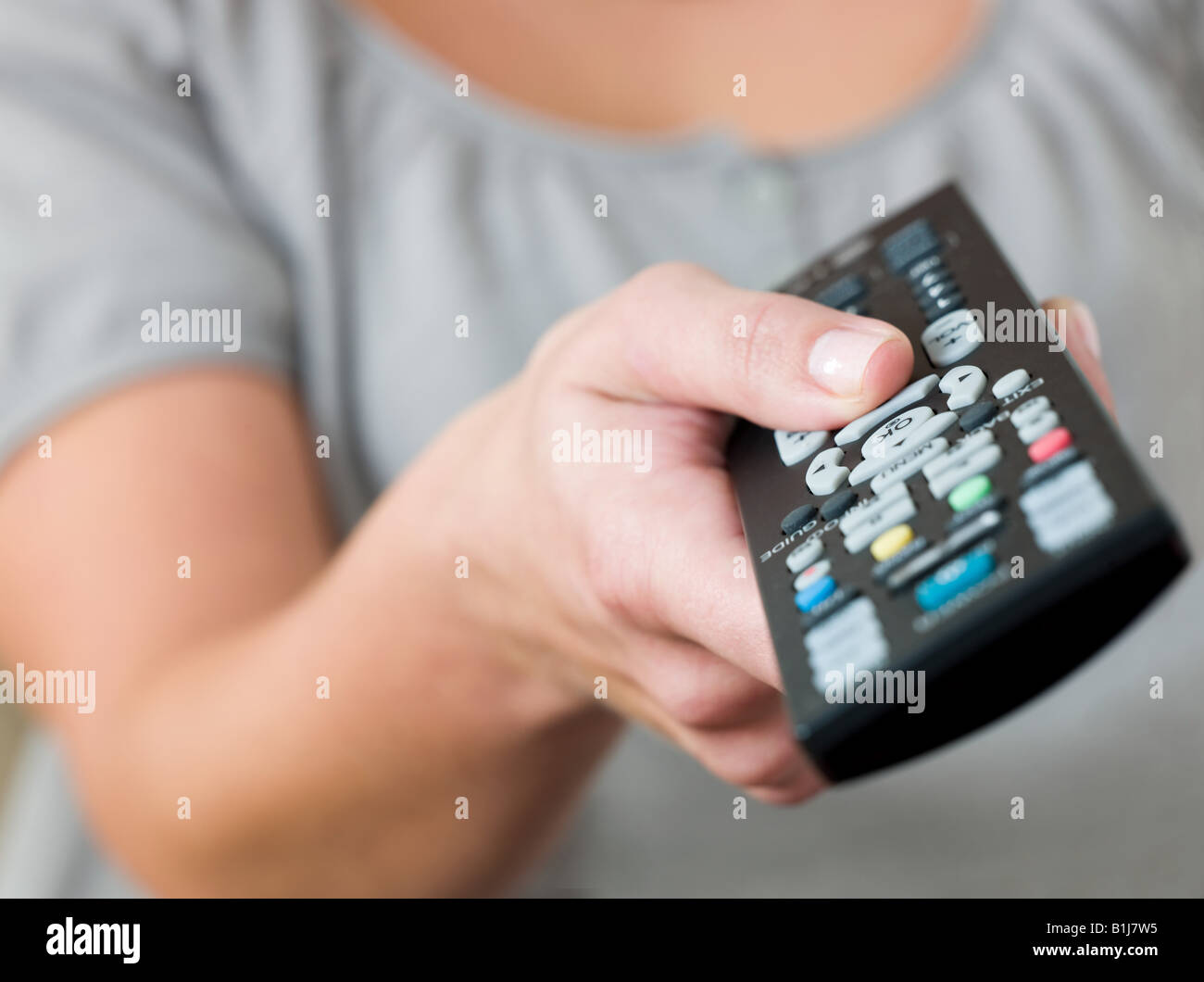 A woman pointing a remote control Stock Photo - Alamy