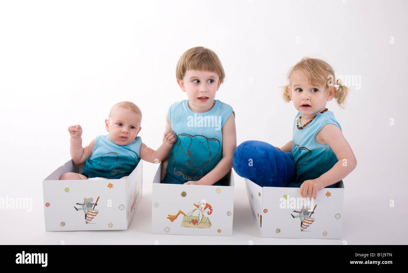 three little children sitting in boxes Stock Photo - Alamy