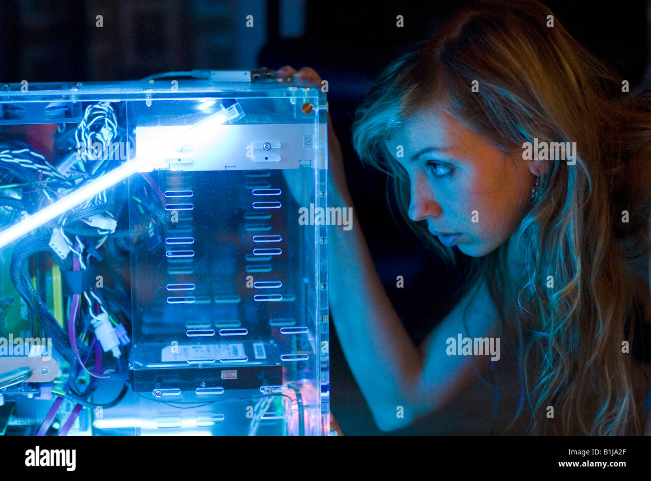 young woman looking into a transparent computer housing Stock Photo - Alamy