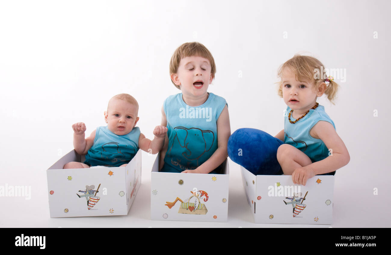 three little children sitting in boxes Stock Photo - Alamy