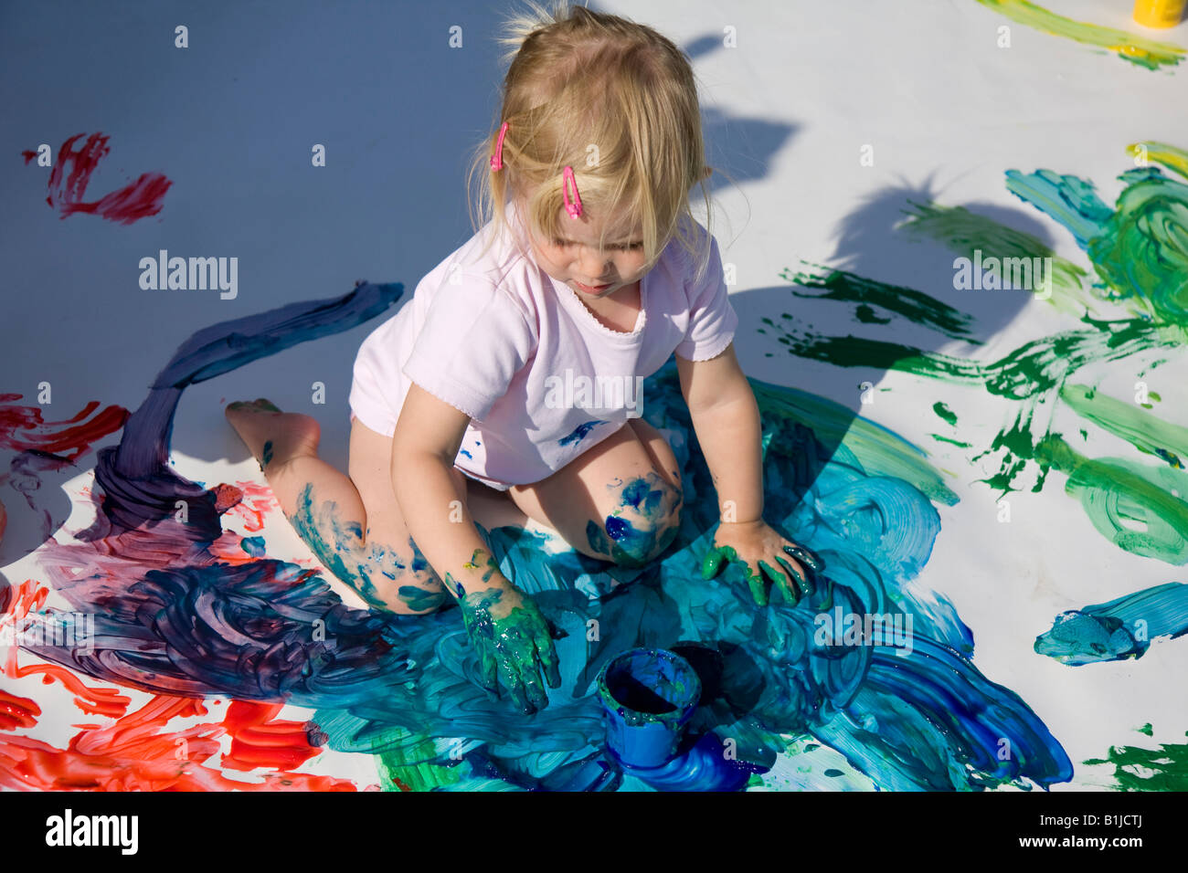little girl painting with finger paint Stock Photo - Alamy