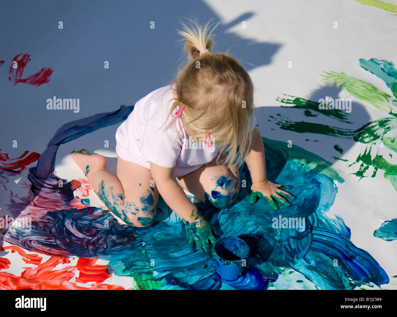 little girl painting with finger paint Stock Photo - Alamy