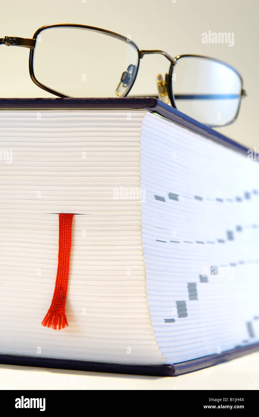 very thick book with spectacles Stock Photo - Alamy
