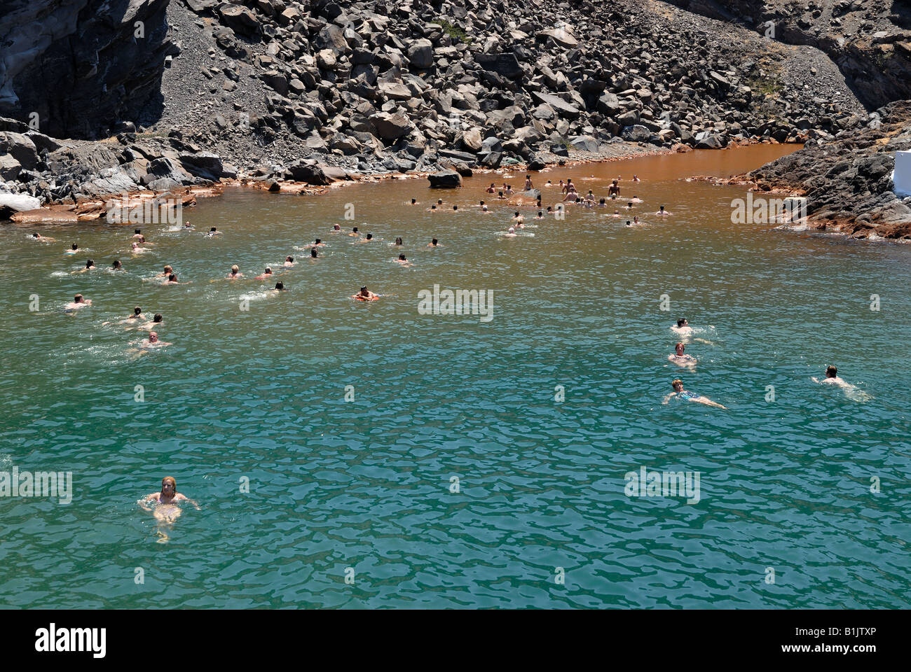 People swimming in the sea at the volcanic island Palea Kameni in ...