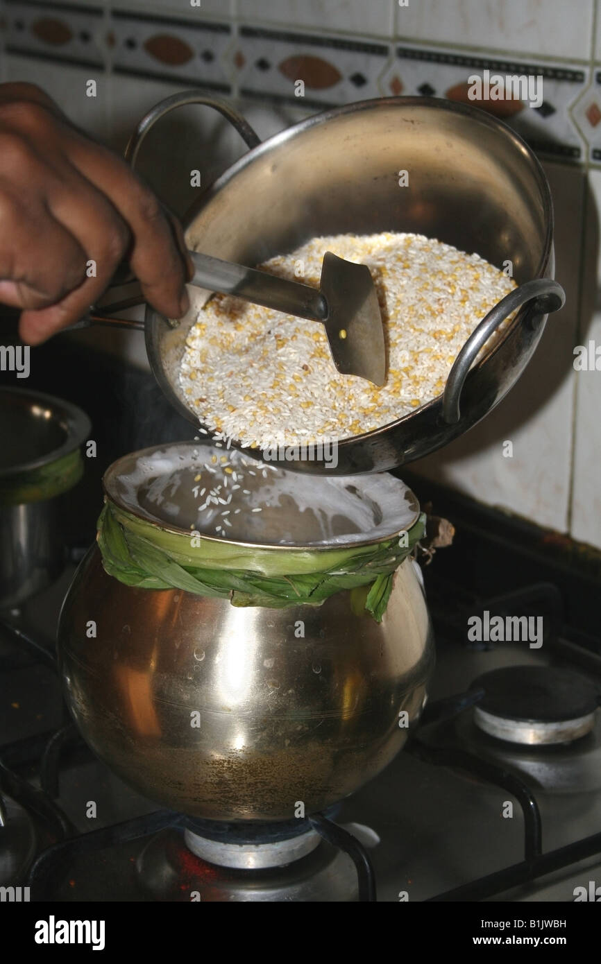 Pongal being prepared using a traditional pot in a modern home in India ...