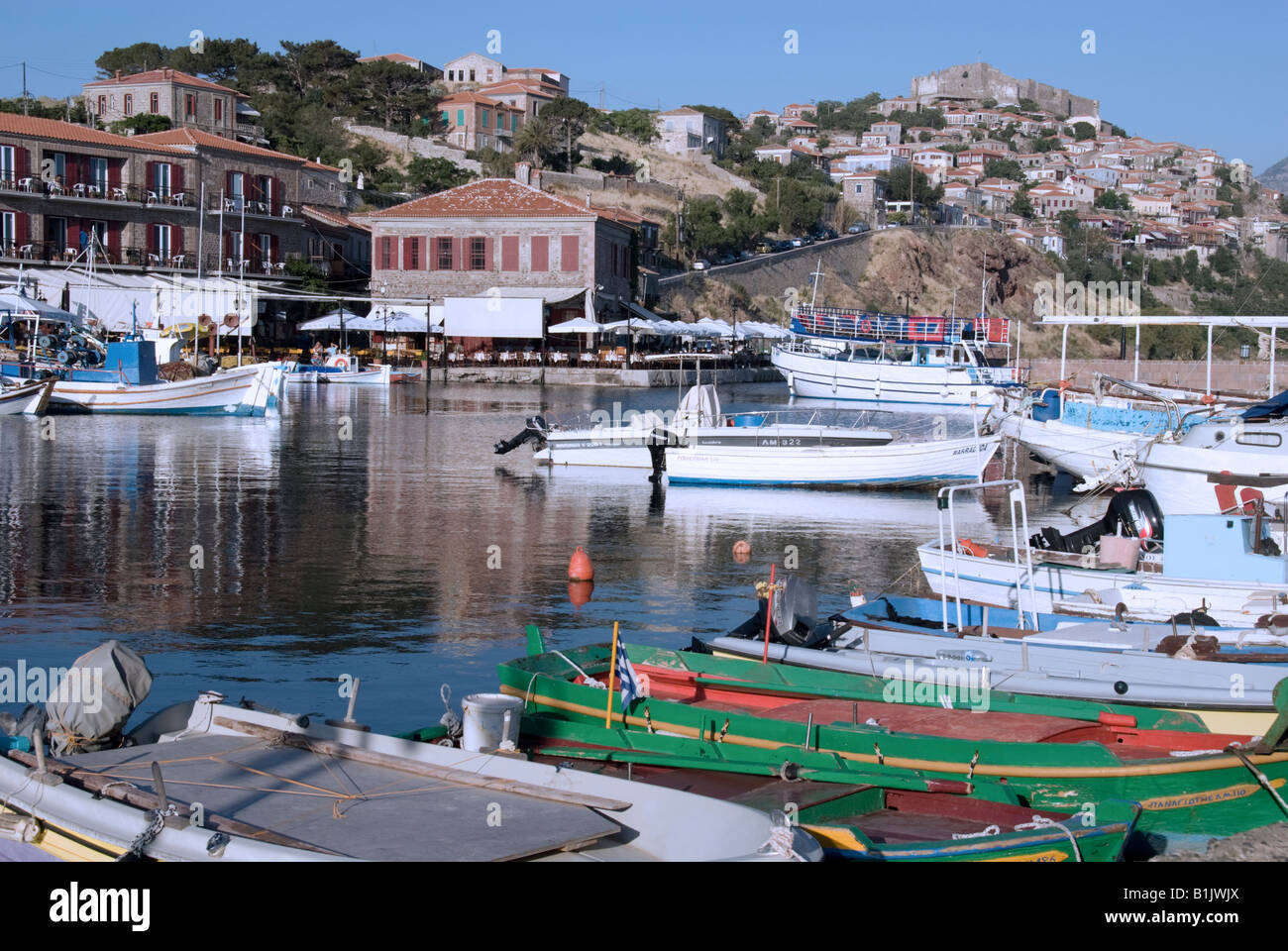 Boats in a Greek harbor with a hillside village in the background Stock ...